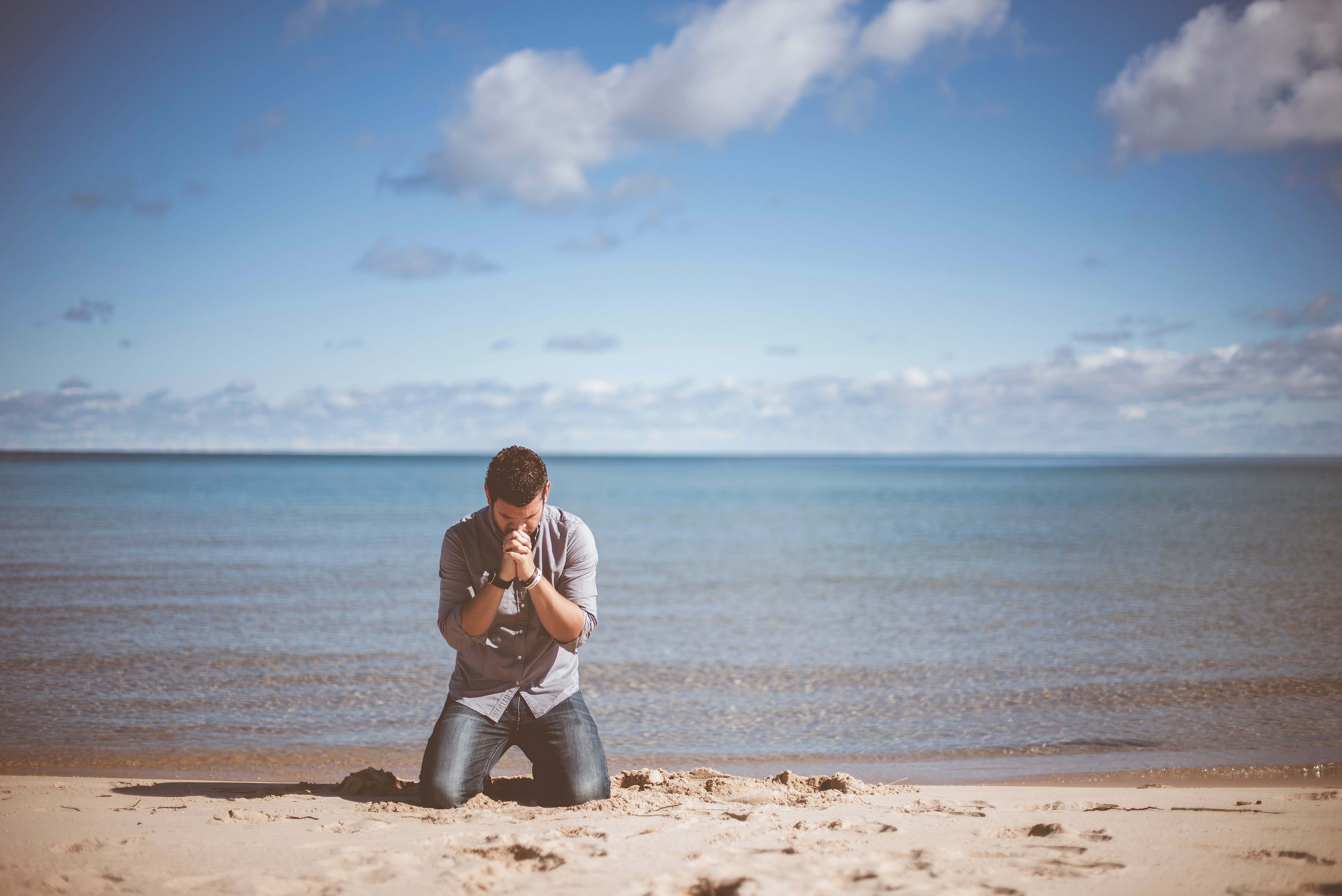 Person Man Kneeling Down Near Shore Beach Image Free Photo
